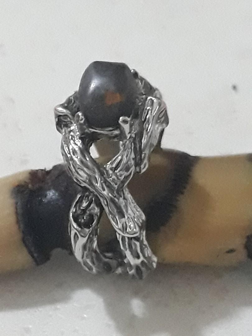 Batu besi tahi bintang di atas bingkai bermotif huruf lam alif (stoney ...