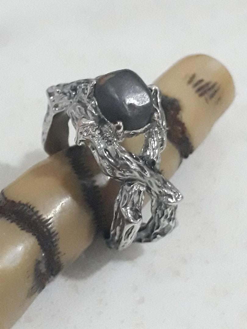 Batu besi tahi bintang di atas bingkai bermotif huruf lam alif (stoney ...