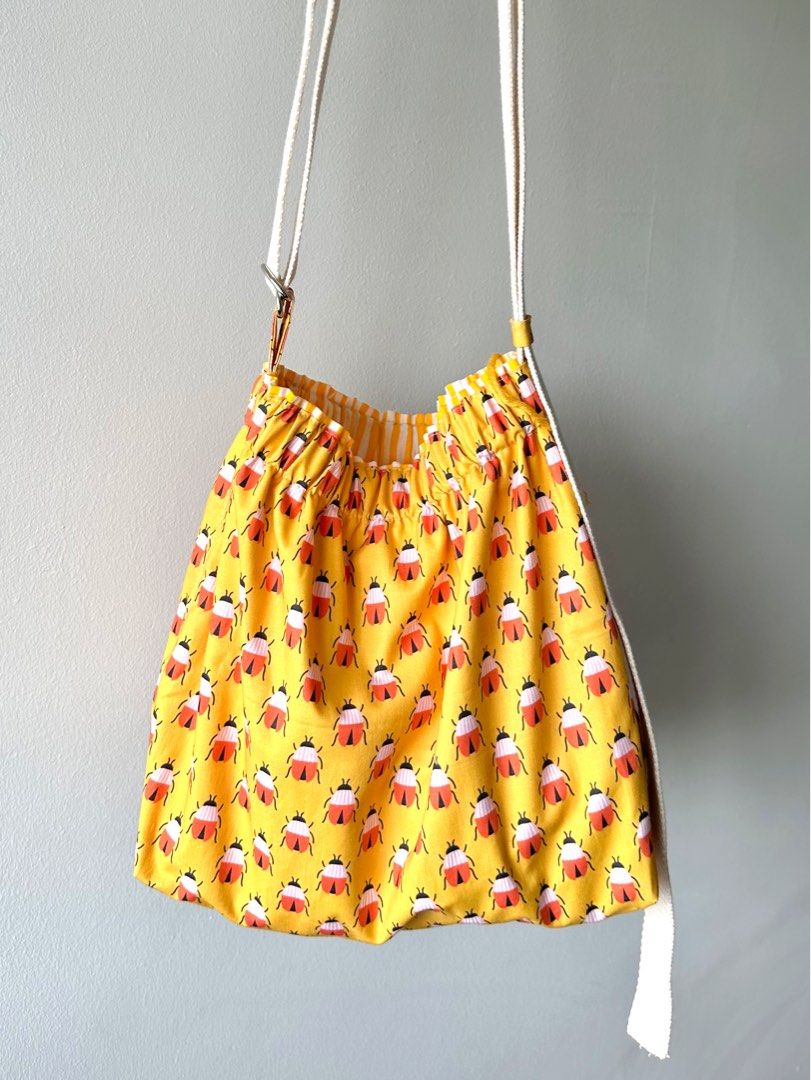 Yellow reversible beetle insect print and striped dumpling sling bag ...