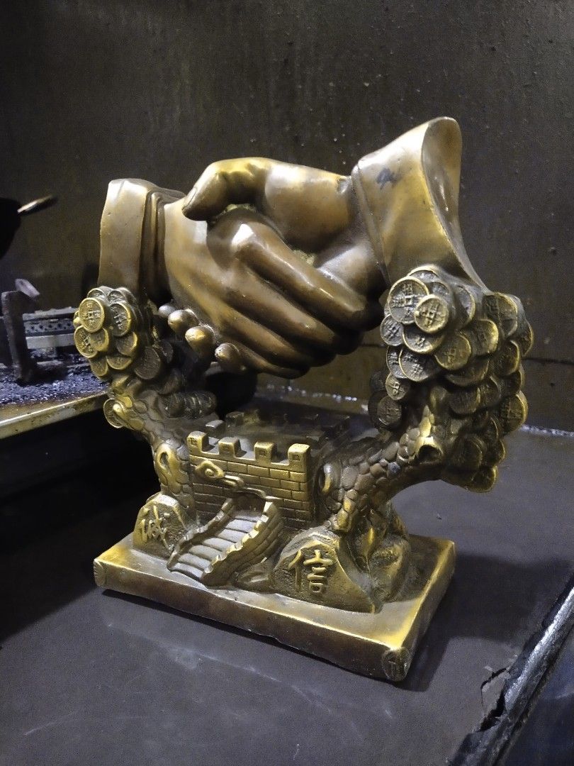 Brass shaking hands statue display on Carousell