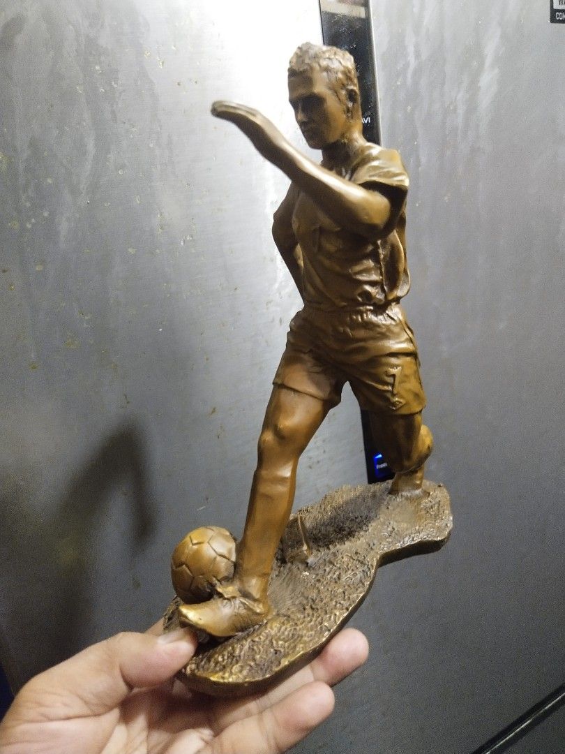 Brass football player statue display on Carousell